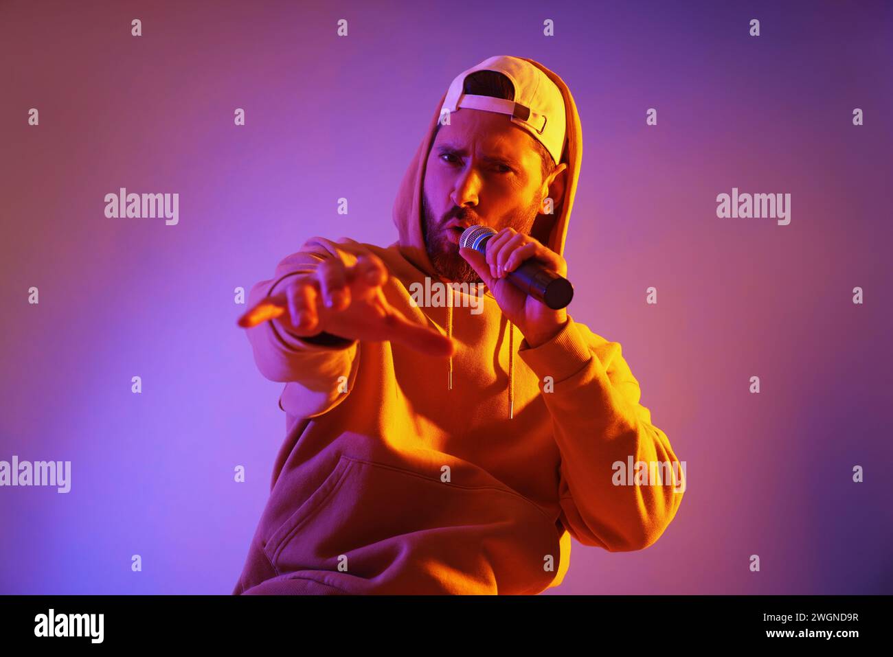 Singer with microphone rapping in color lights Stock Photo - Alamy