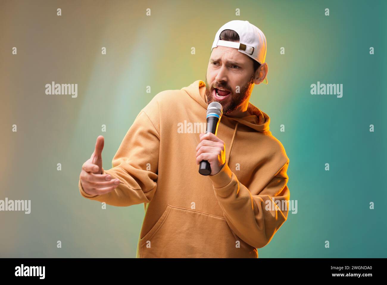 Singer with microphone rapping in color lights Stock Photo - Alamy