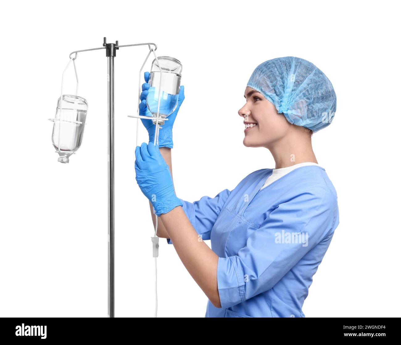 Nurse setting up IV drip on white background Stock Photo - Alamy