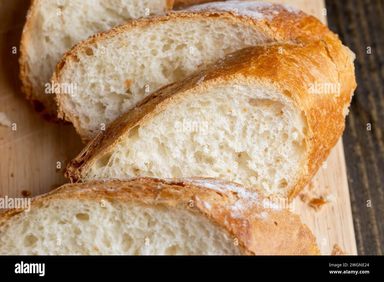 Cut white bread into pieces, traditional white baguette with porous ...