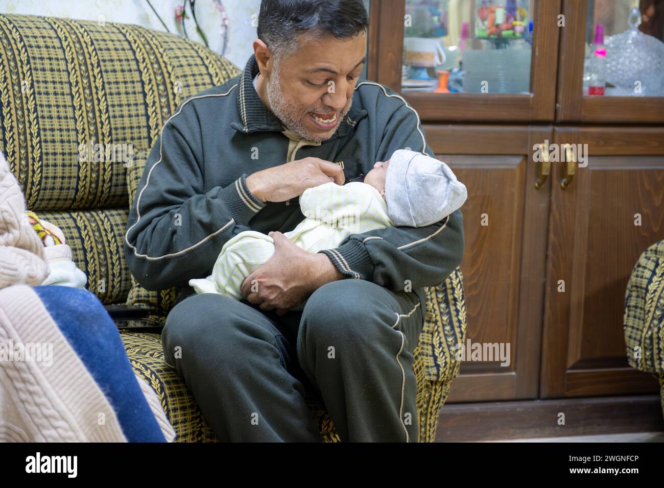 Grandfather holding baby with smile on his face, grey beard , baby ...