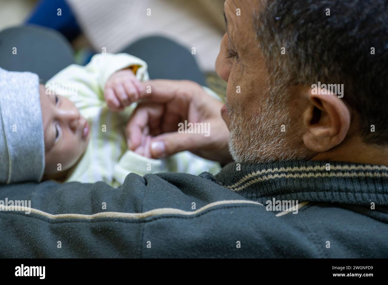 Grandfather holding baby with smile on his face, grey beard , baby ...