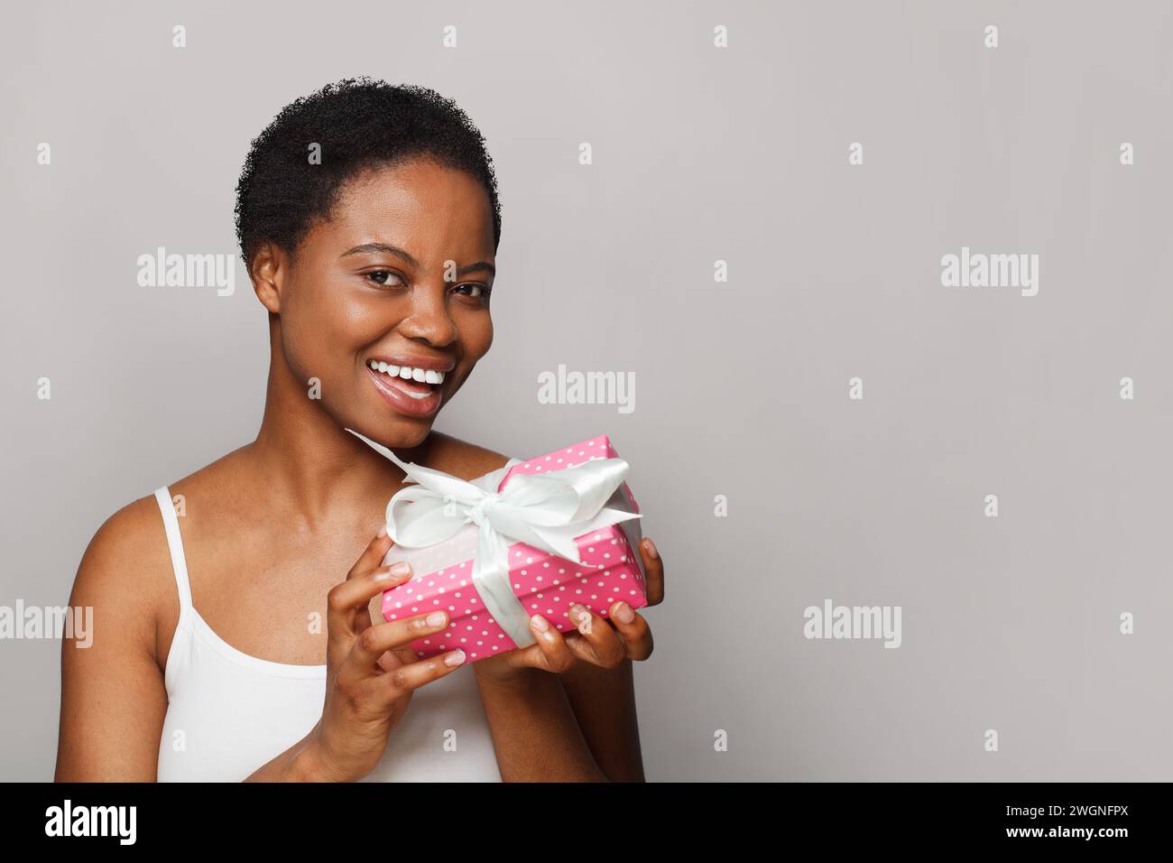 Joyful healthy woman holds colorful gift present box on white ...