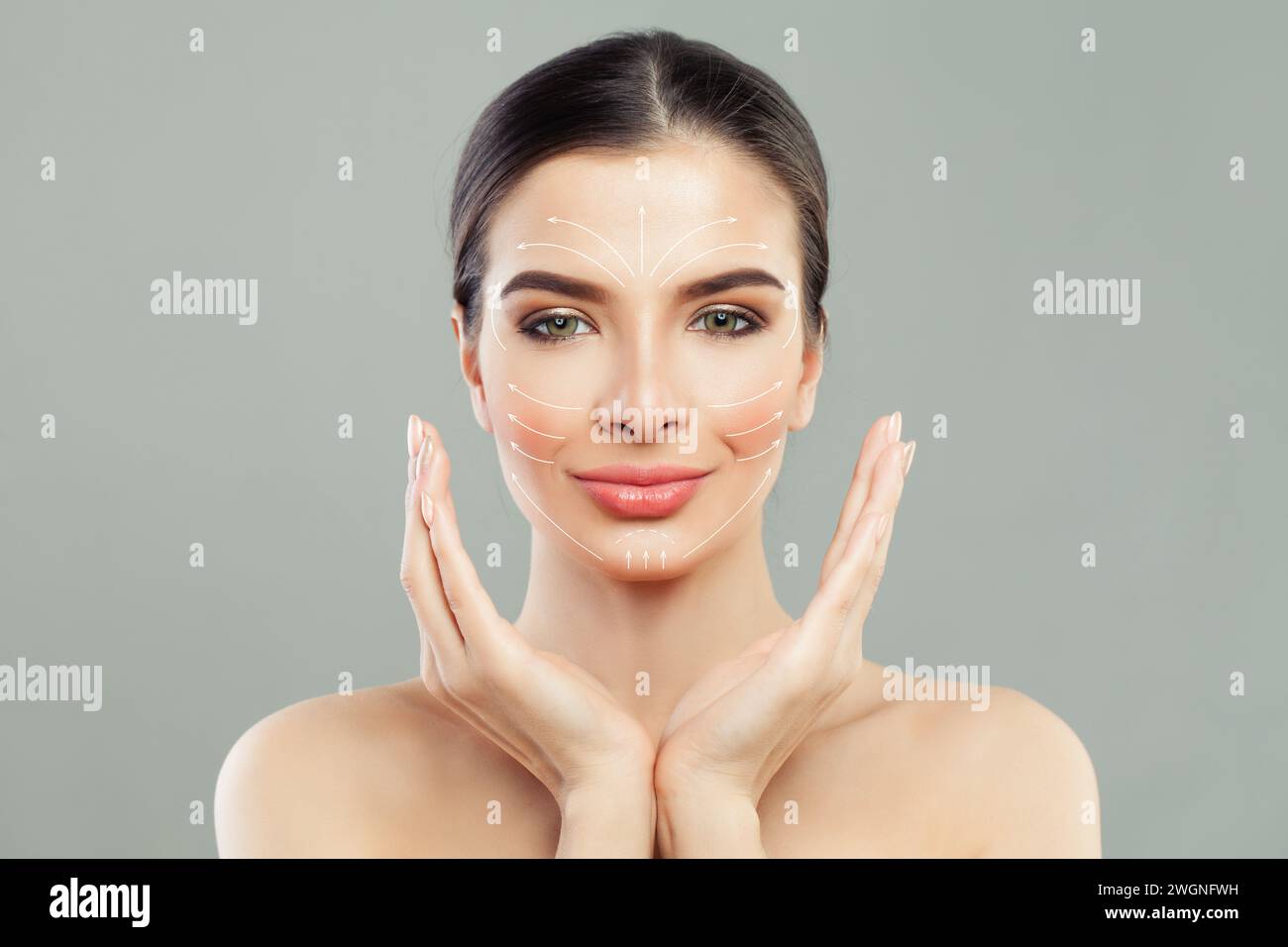 Pretty female face with clean skin, holding hands near face with ...
