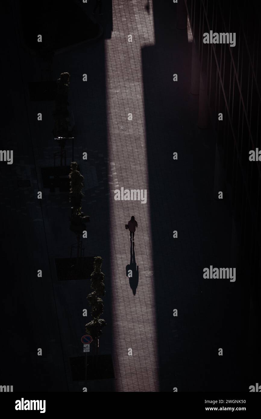 Person walks in the light casting a shadow Stock Photo - Alamy