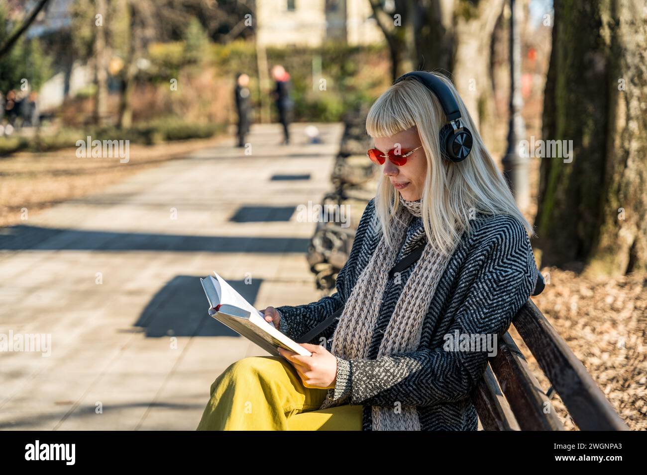 Lovely blonde young hippie girl listening music with wireless headset ...