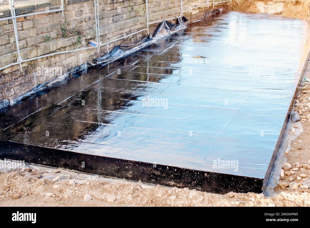 Waterproofing coating. Builder applying waterproofing bitumen mastic on ...