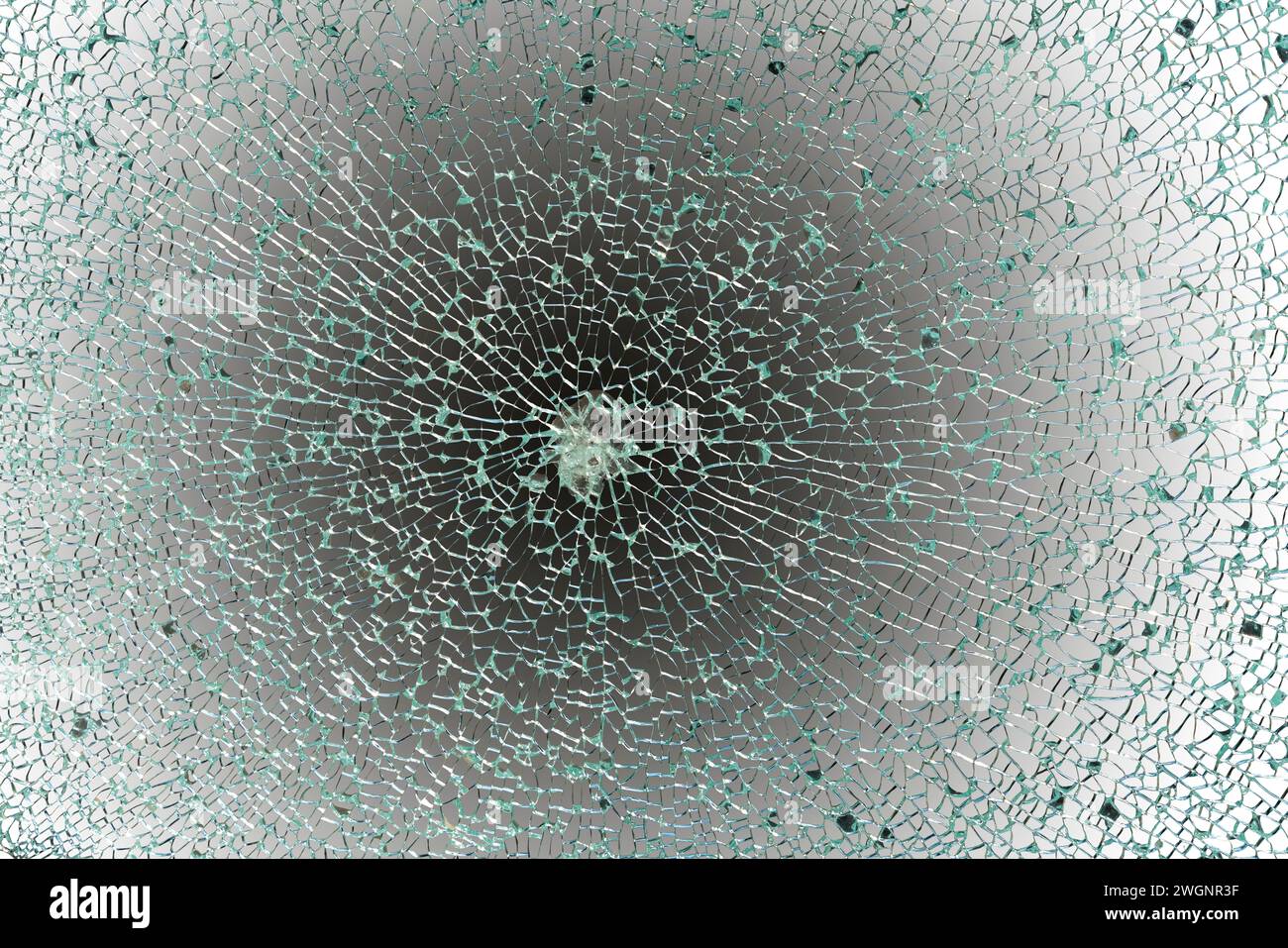Full frame shot of a broken safety glass pane in gradient radial back ...