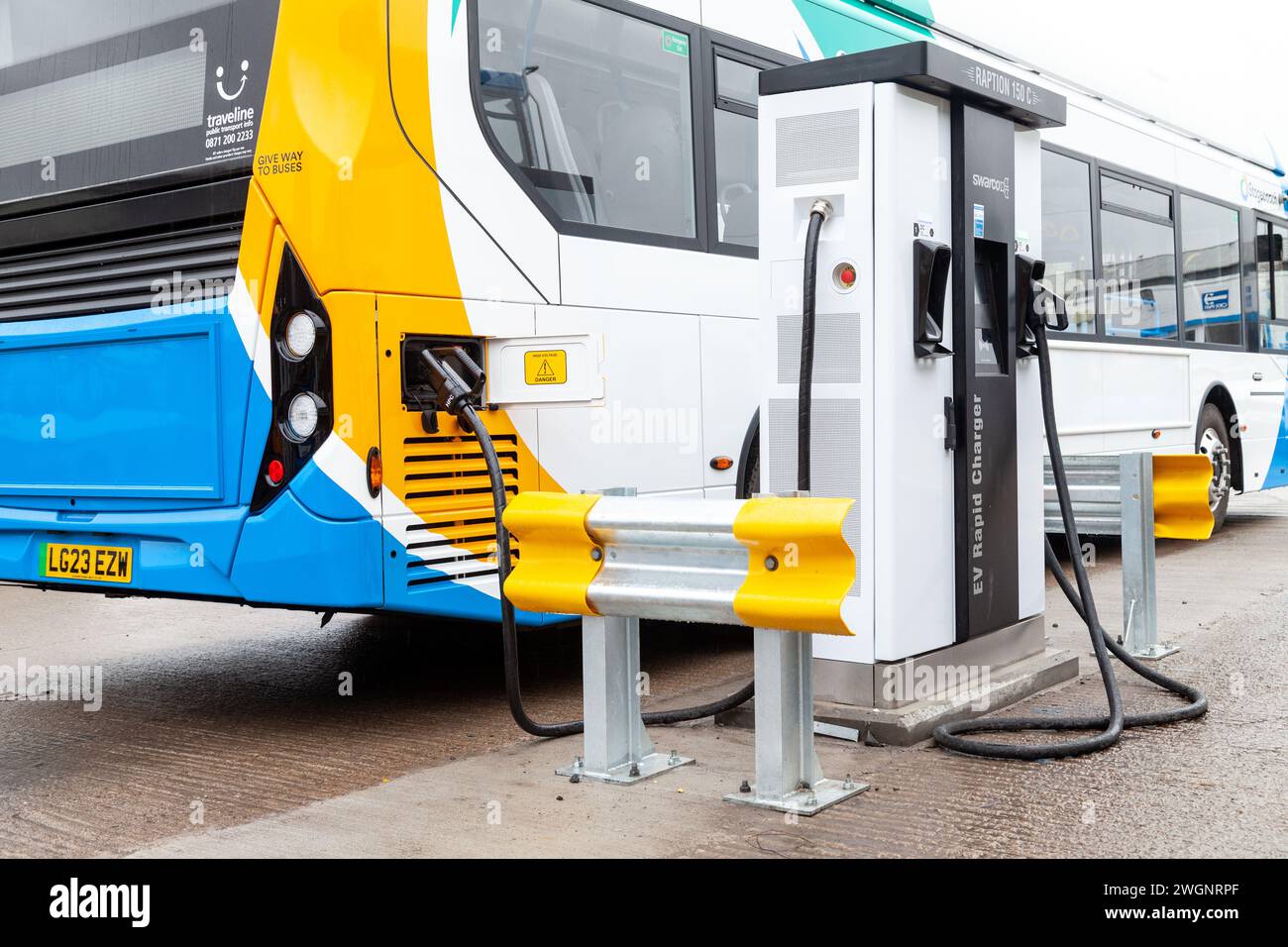 An electric bus being charged in a bus depot in Scotland Stock Photo ...