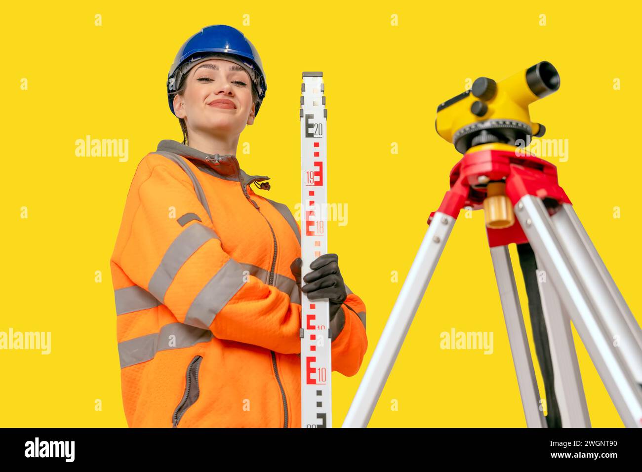 Woman in hard hat and protective clothes land surveyor working with ...