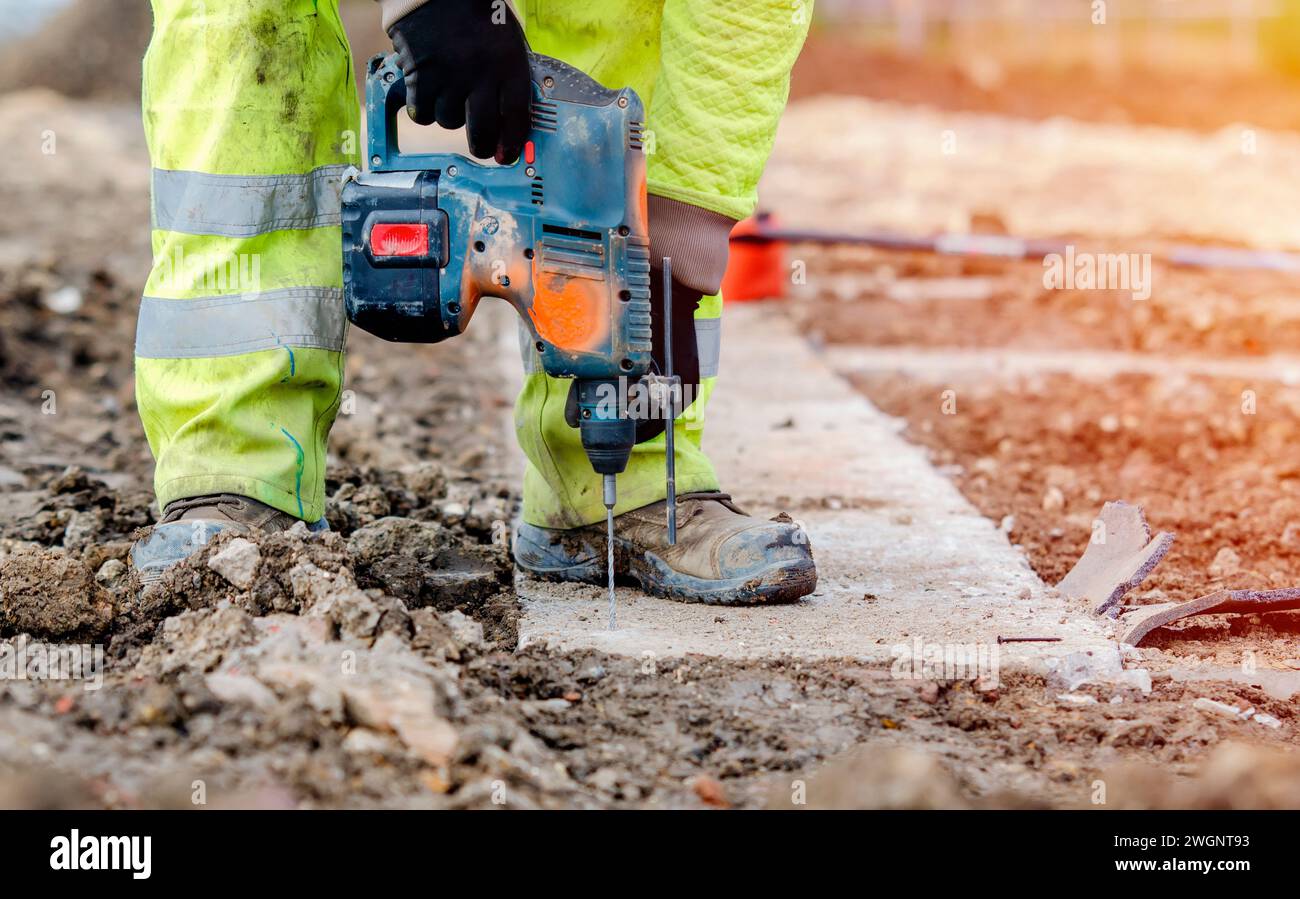 Builder drilling through hard concrete with a cordless drill Stock ...