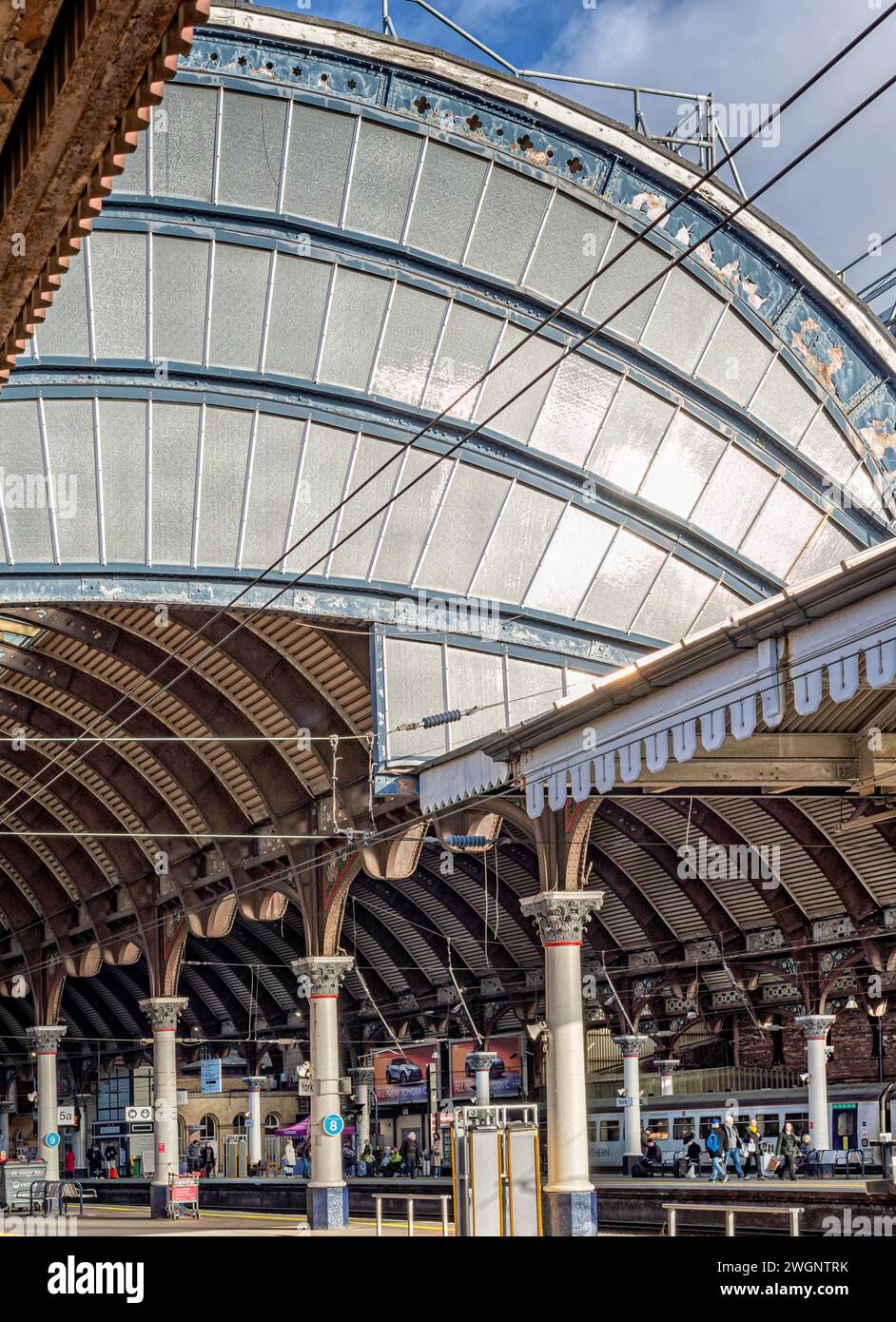 A 19th century metal arch with glass panels dominates a railway station ...