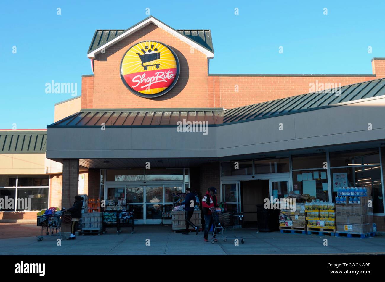 A person pushes a shopping cart in front of a ShopRite grocery market ...
