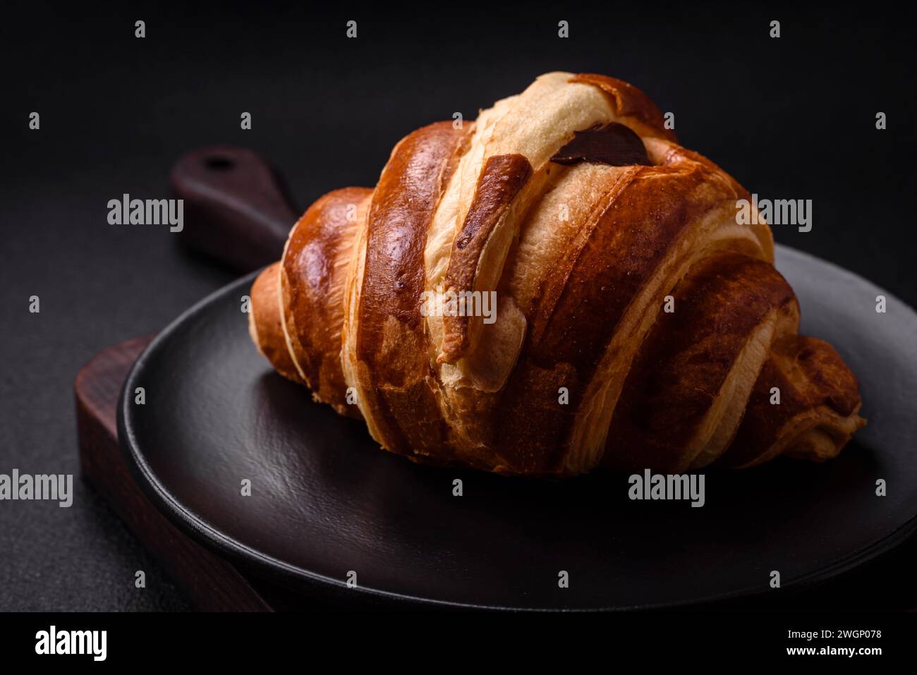 Delicious crispy sweet croissant cornet with chocolate on a dark ...