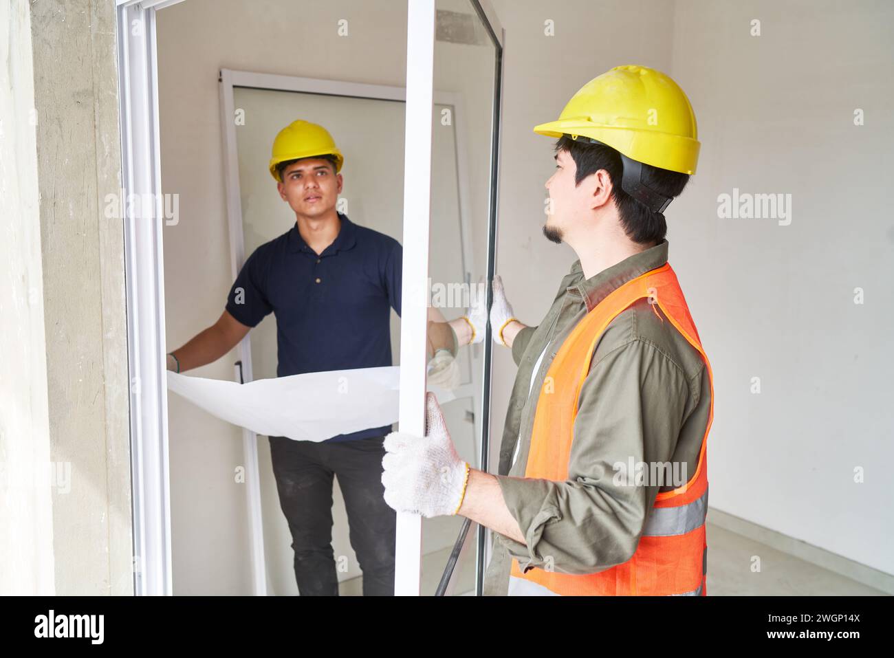 Young carpenters installing window frame Stock Photo - Alamy