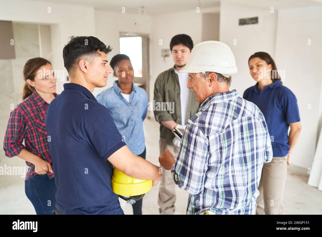 Architect supervisioning team group of construction workers onsite in ...