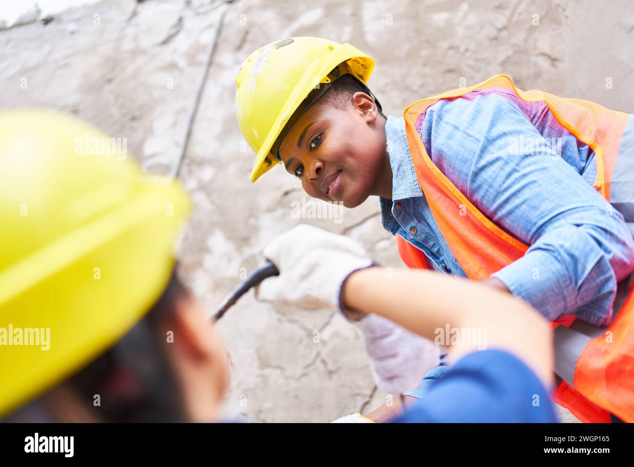 Diverse female bricklayers holding bucket together Stock Photo - Alamy