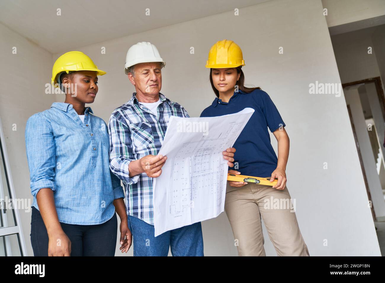 Contractor discussing over blueprint with workers Stock Photo - Alamy