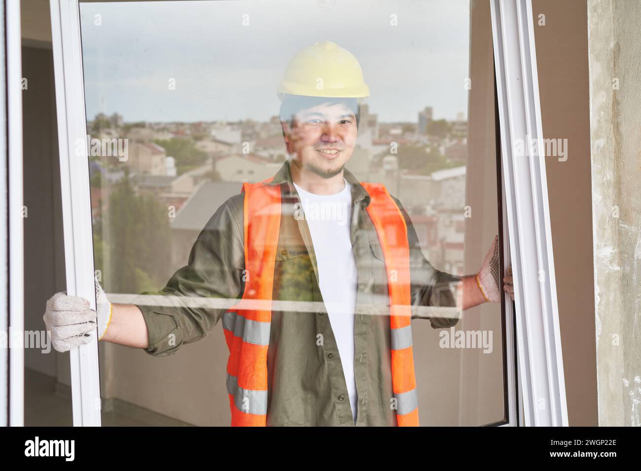 Smiling young male worker carrying window frame Stock Photo - Alamy
