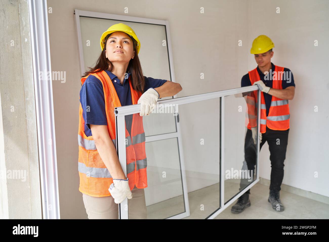 Carpenters carrying window in house Stock Photo - Alamy