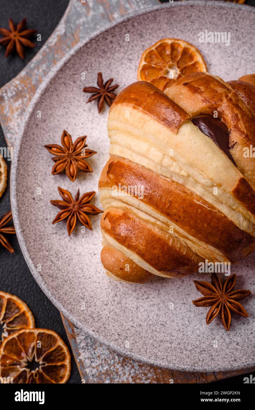 Delicious crispy sweet croissant cornet with chocolate on a dark ...