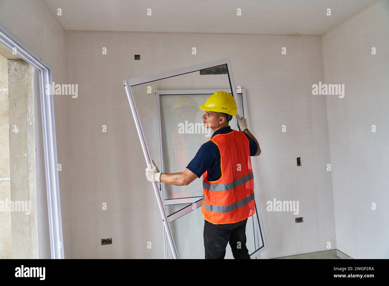 Young male carpenter installing window frame Stock Photo - Alamy