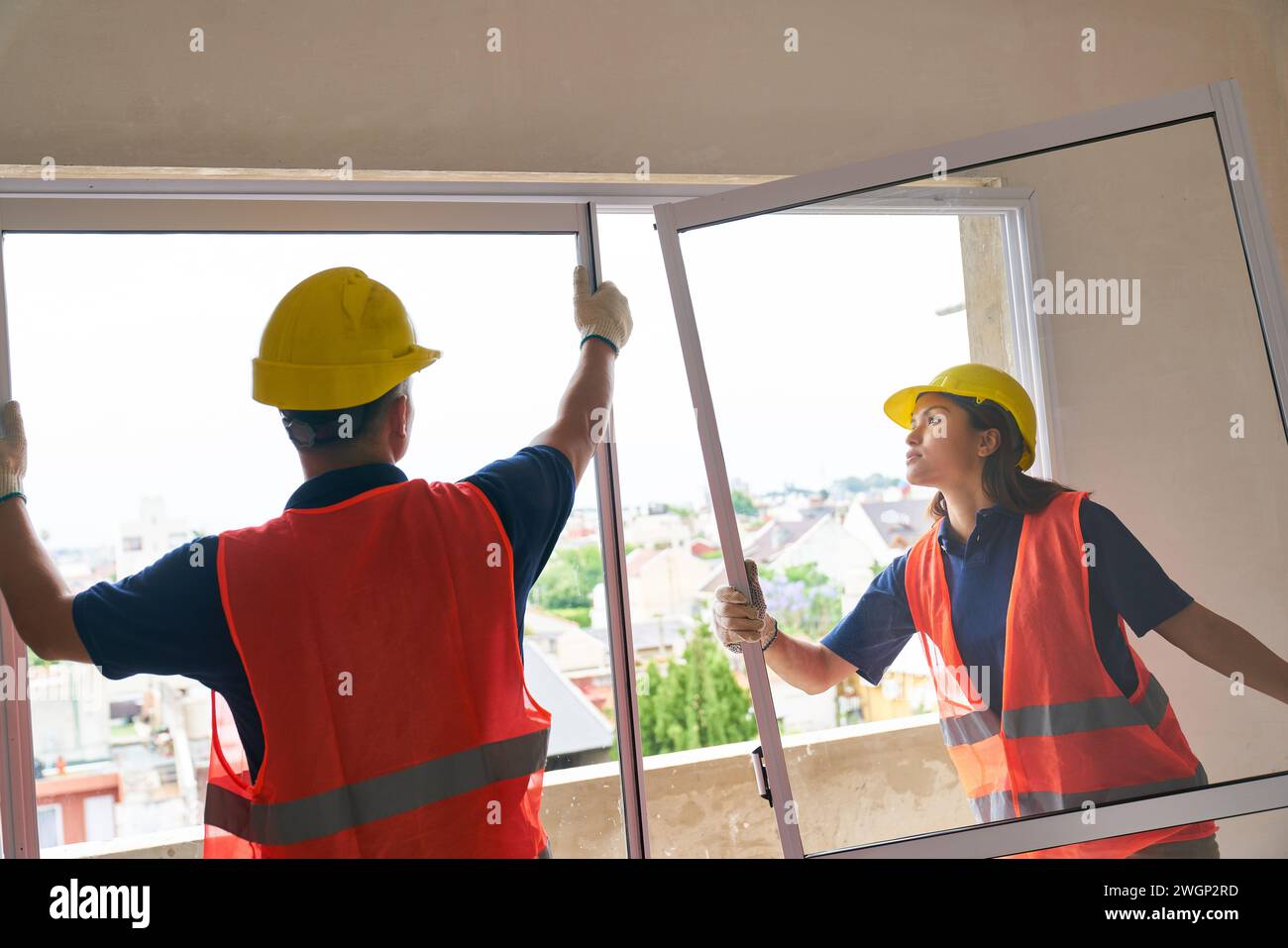 Carpenters installing window frames in house Stock Photo - Alamy