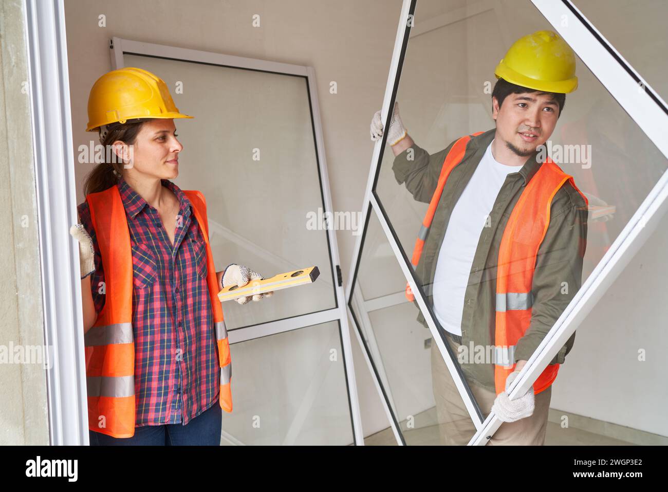 Carpenters installing window frame Stock Photo - Alamy