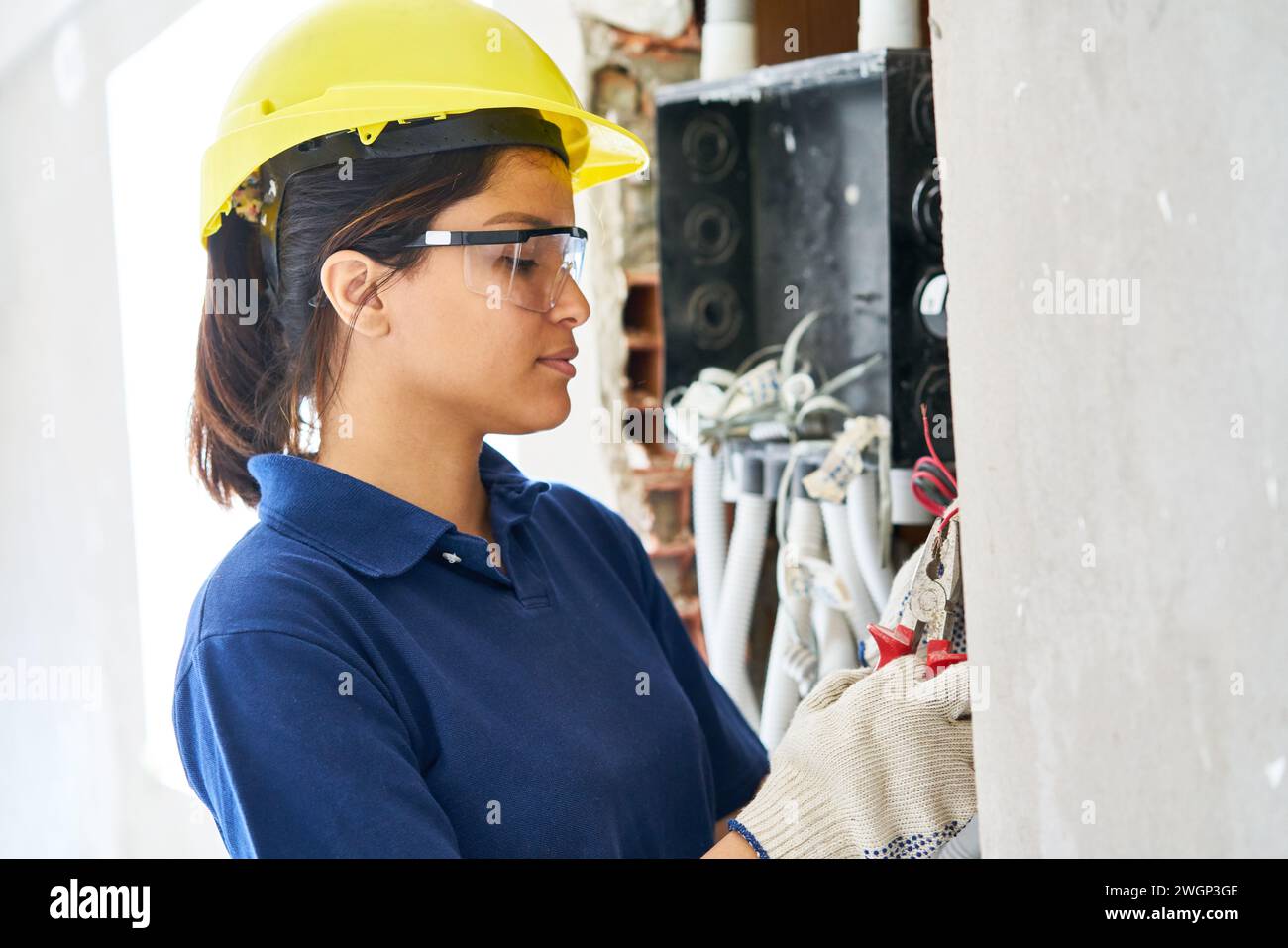 Female electrician using pliers while fixing cables Stock Photo - Alamy