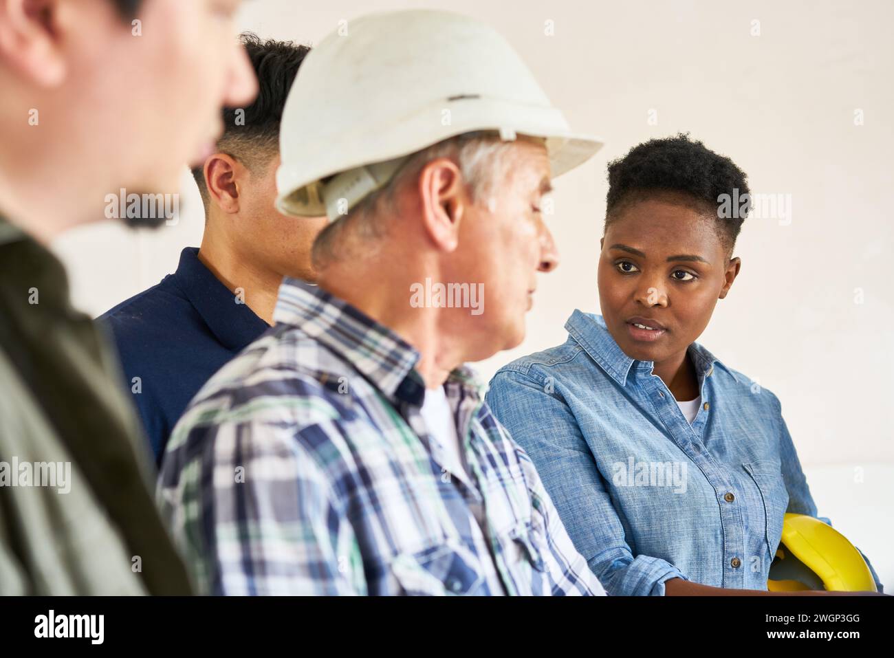 Female worker discussing with male coworkers Stock Photo - Alamy