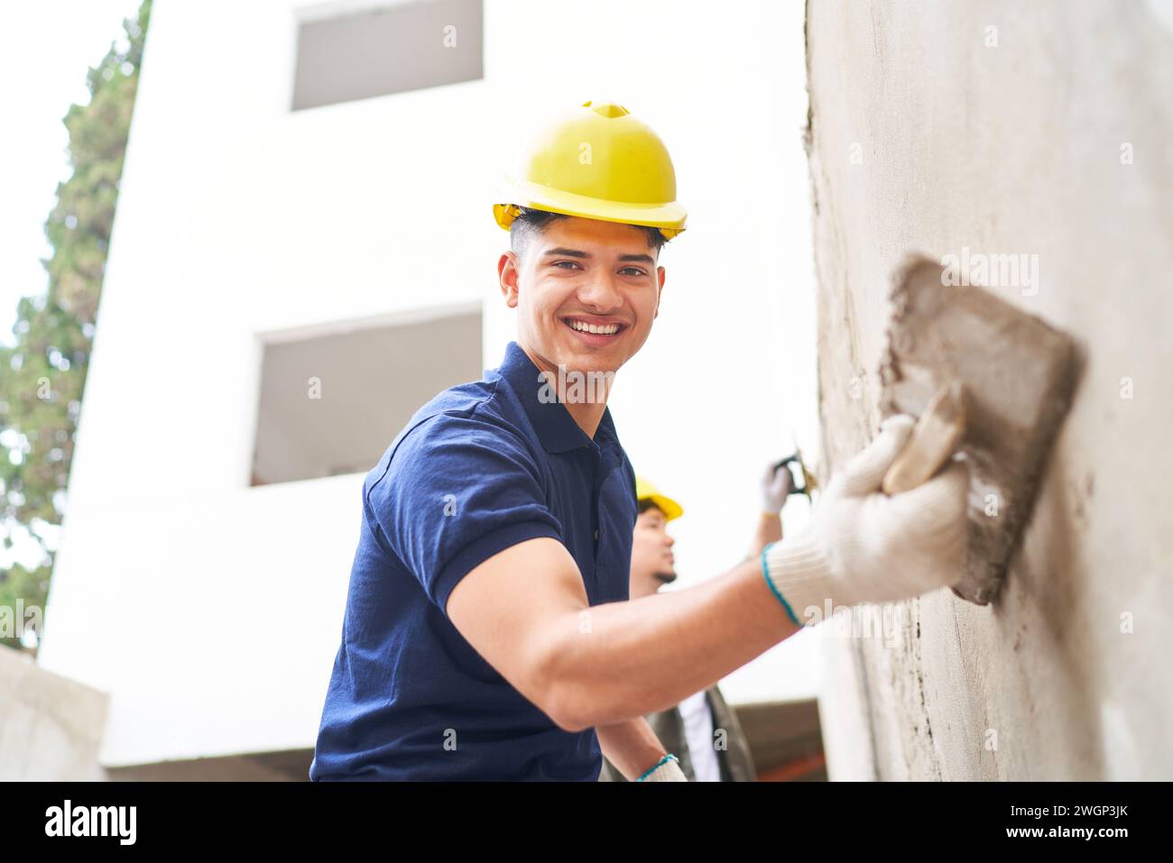 Smiling male labor plastering wall with concrete Stock Photo - Alamy