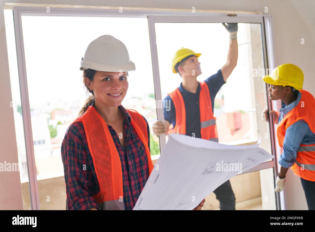 Contractor with blueprint near carpenters at site Stock Photo - Alamy