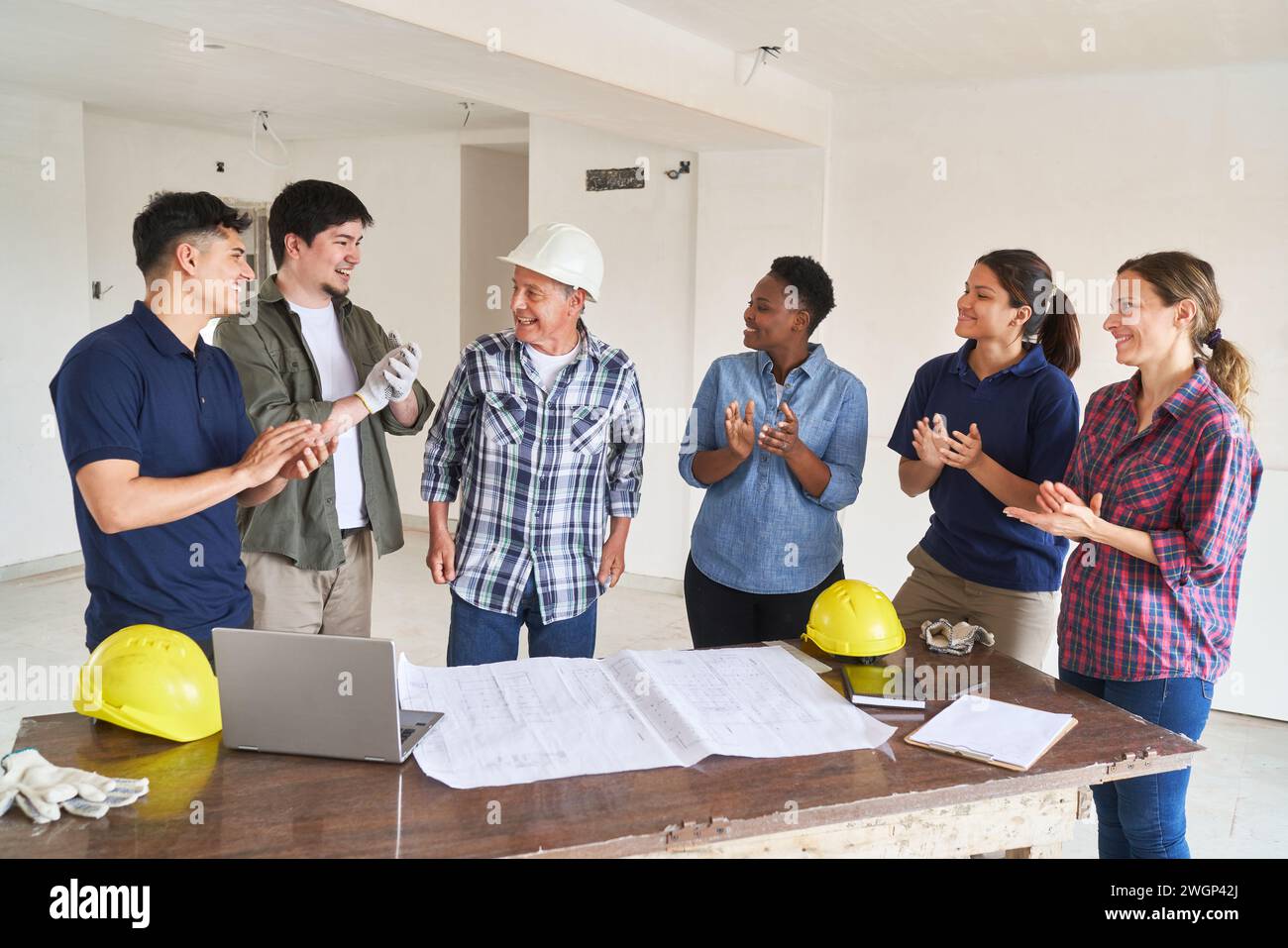 Team of workers applauding architect in meeting Stock Photo - Alamy