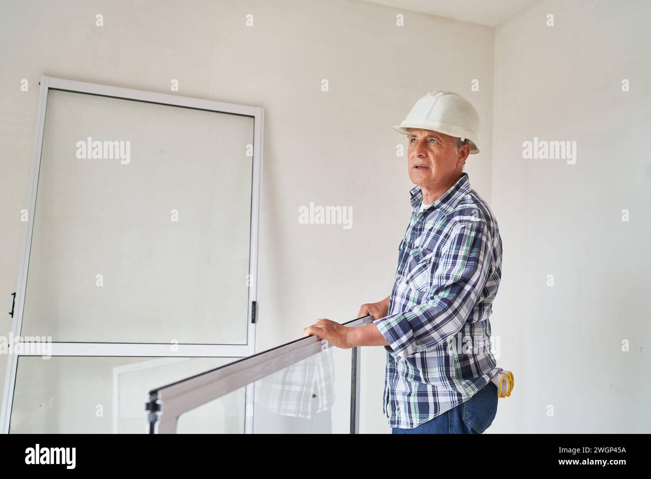 Senior male supervisor standing with window frame Stock Photo - Alamy