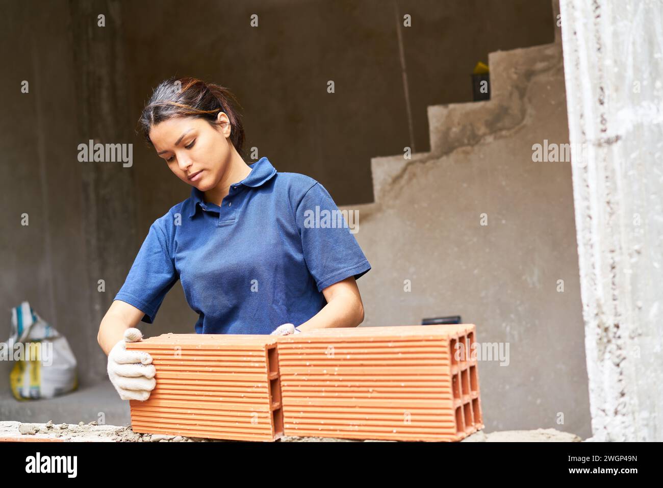 Female bricklayer poistioning brick on wall Stock Photo - Alamy