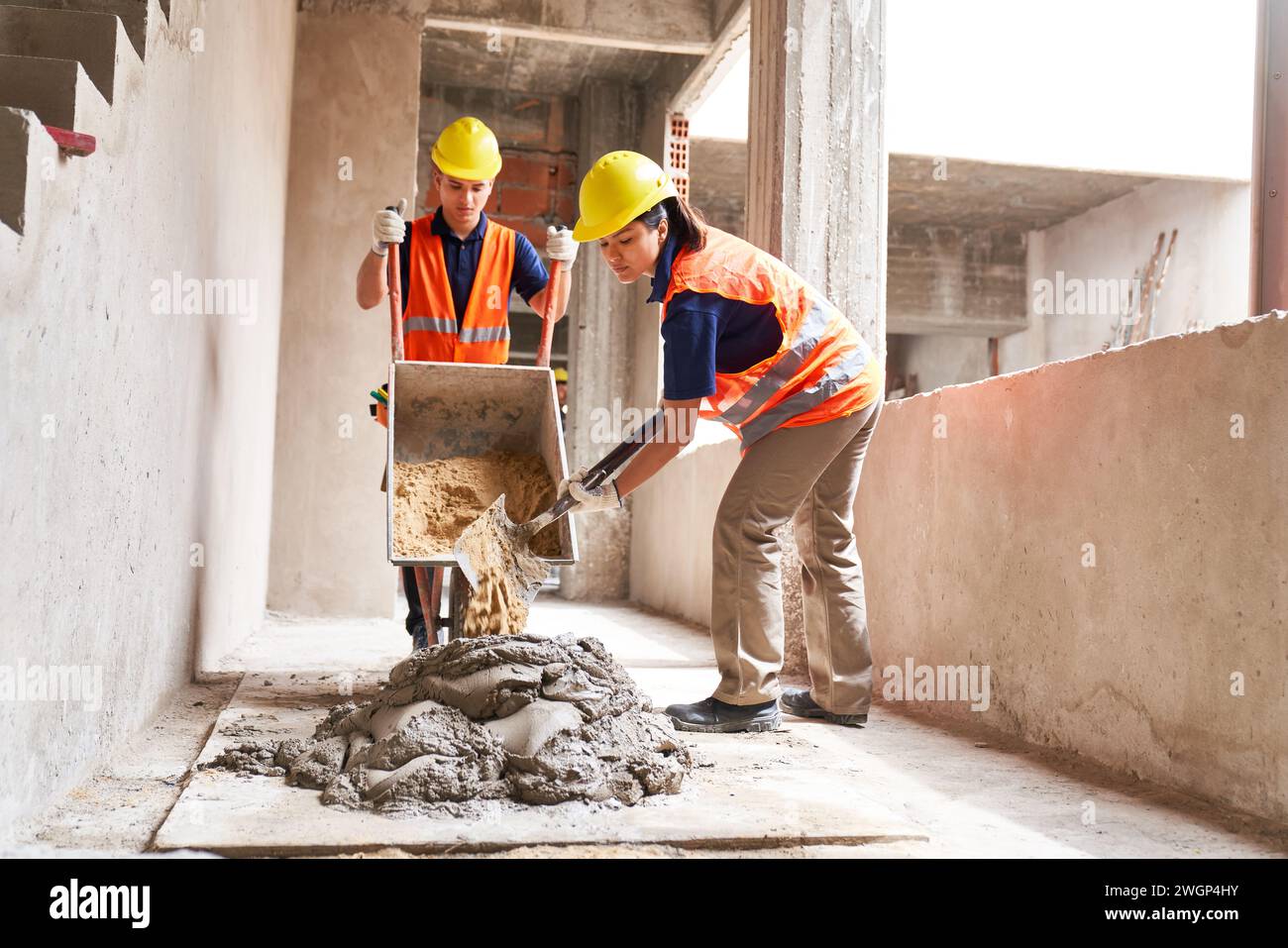 Young male and female masons working together Stock Photo - Alamy