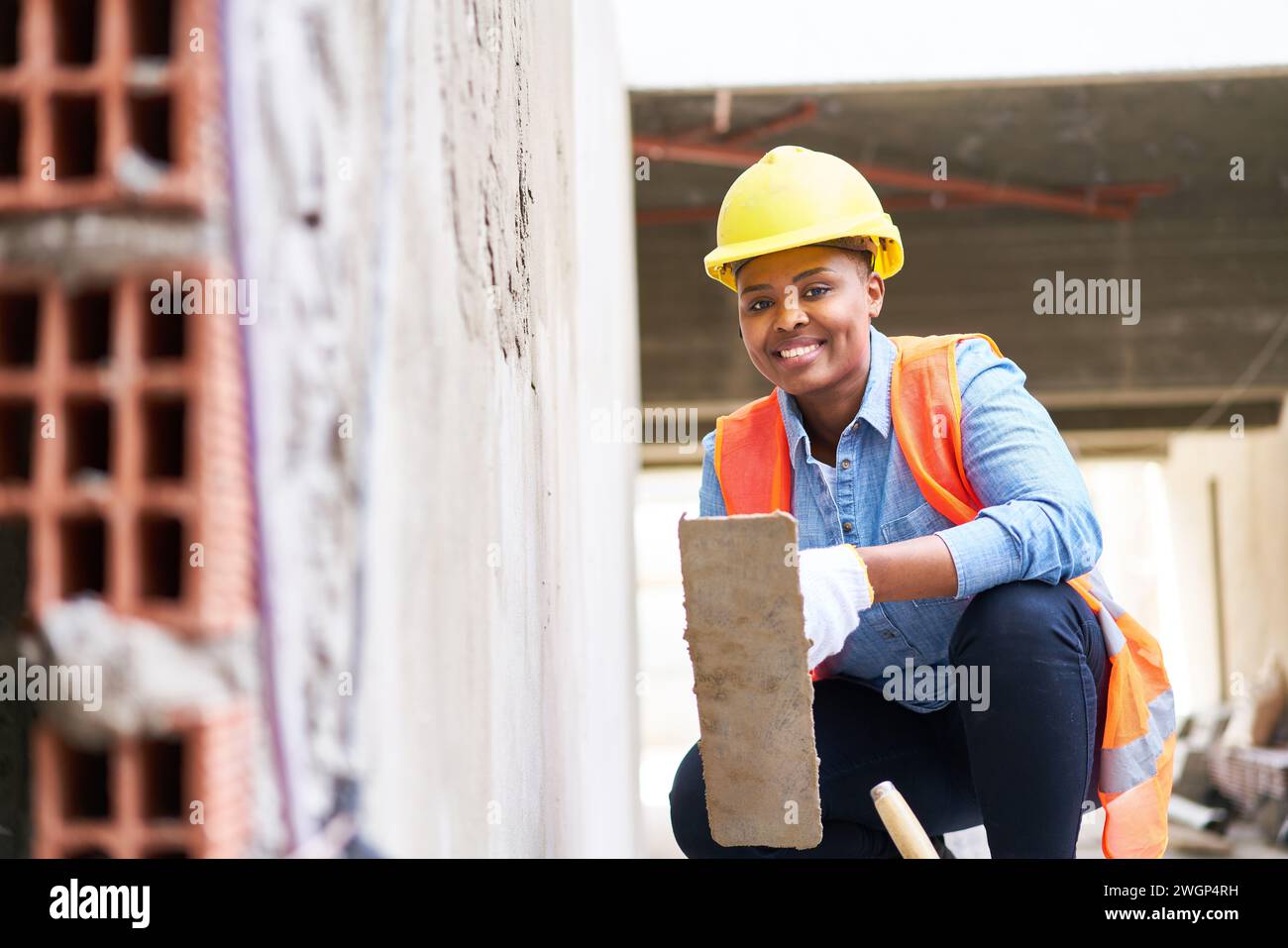 Happy female labor with trowel on plank Stock Photo - Alamy