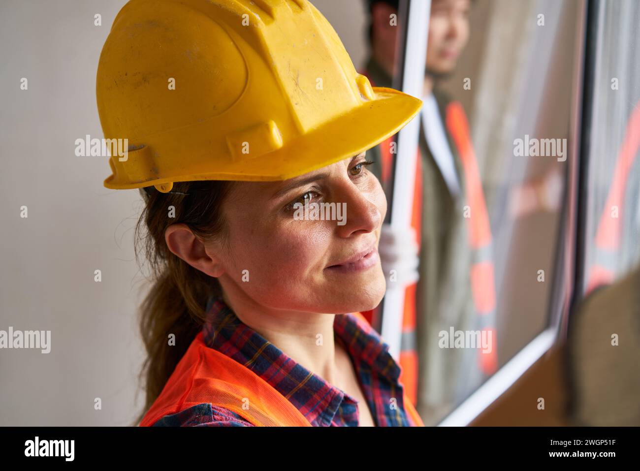 Female carpenter carrying window frame Stock Photo - Alamy