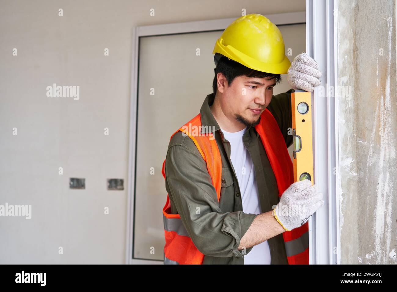 Confident male carpenter examining frame with level Stock Photo - Alamy