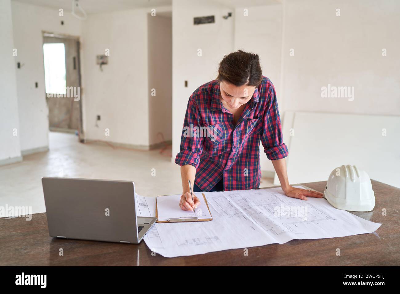 Young architect writing on clipboard over blueprint Stock Photo - Alamy