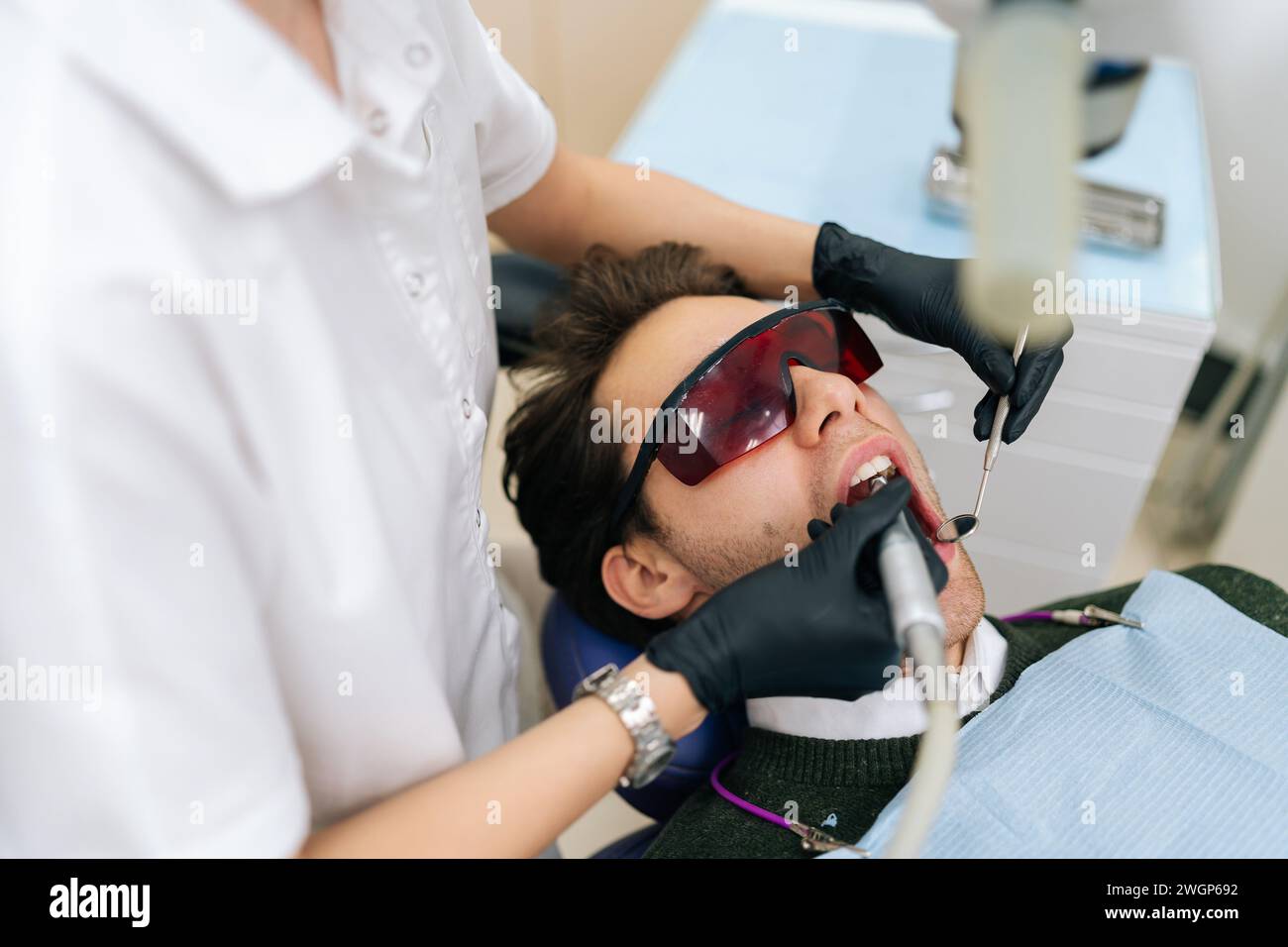 Female dentist using modern diode dental laser for periodontal care ...