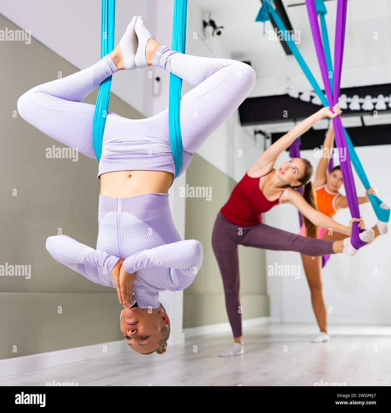 Different inversion aerial yoga with hammock Stock Photo - Alamy