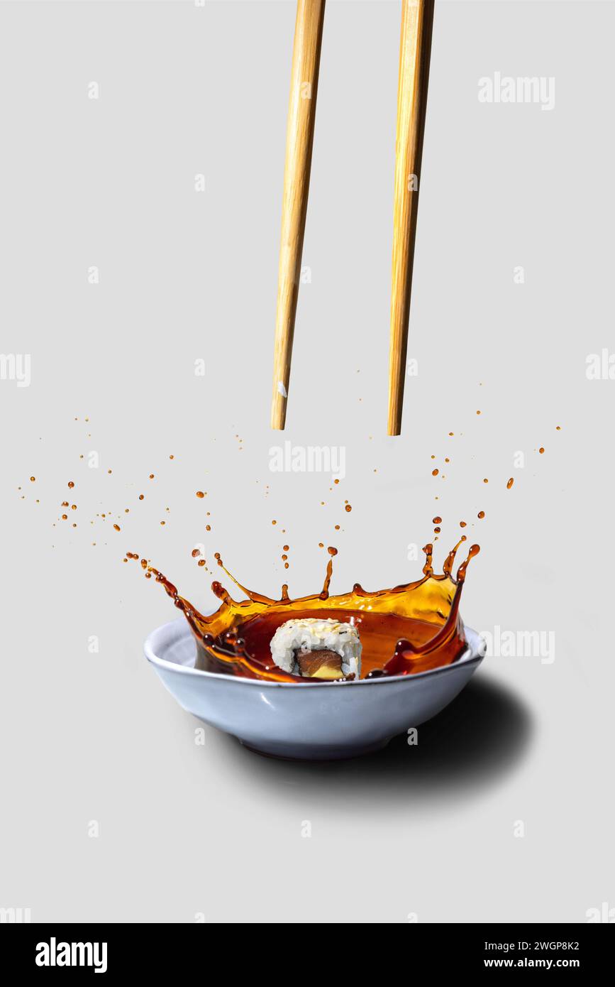 Sushi falling from chopsticks into a bowl of soya sauce Stock Photo - Alamy