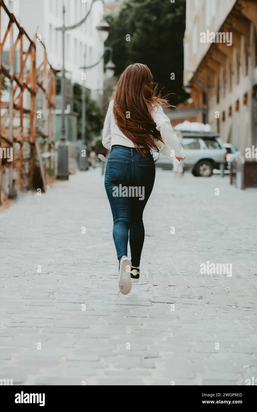 Rear view woman running away outdoors Stock Photo - Alamy
