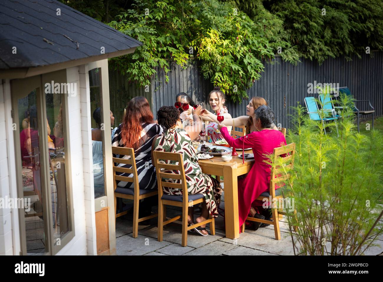 A mixed gathering of women laughing and having fun at a summer garden ...