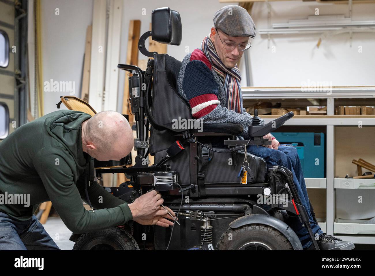 Mechanic working on mans prototype wheelchair Stock Photo - Alamy