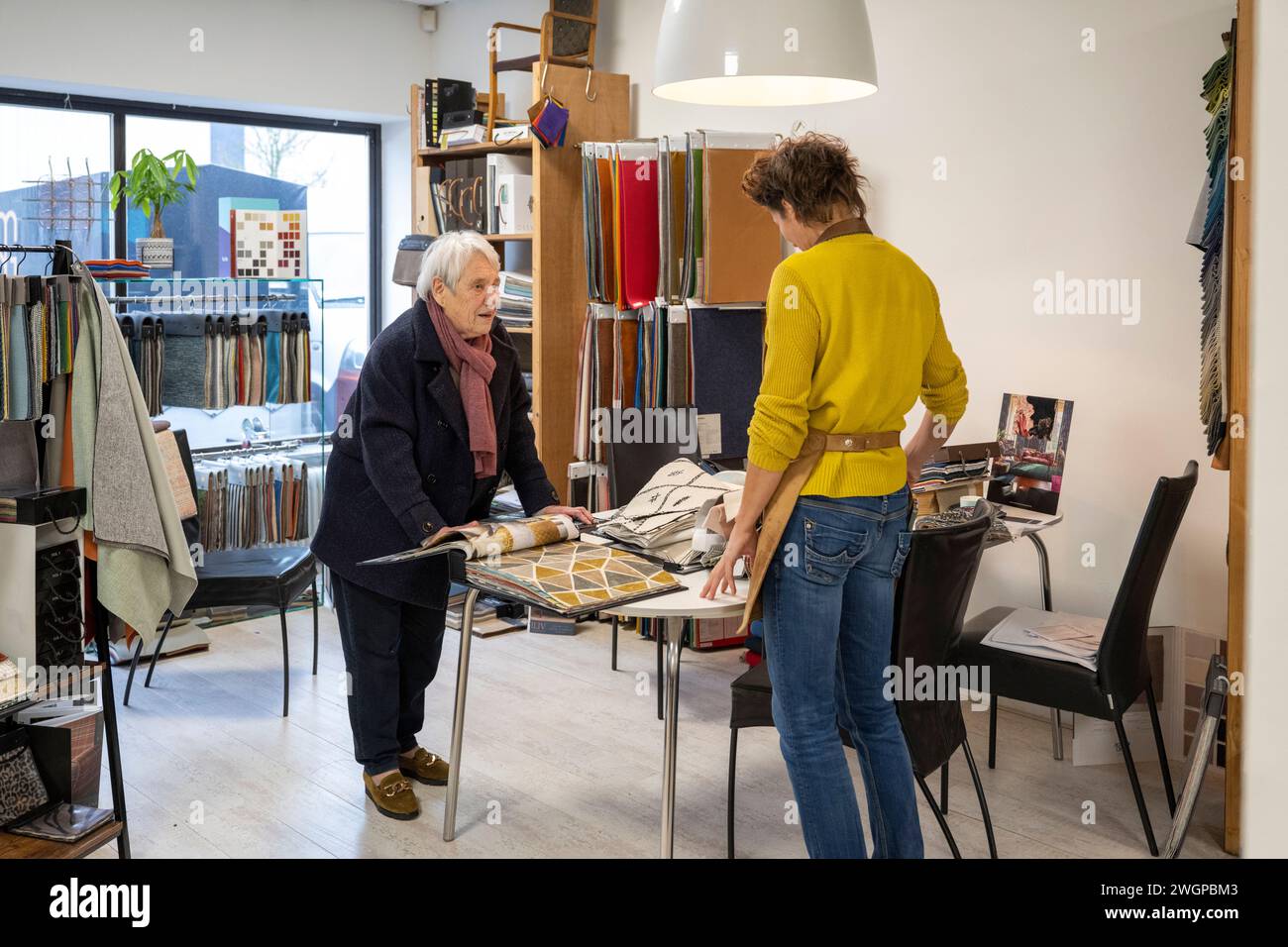 Female upholstery helping client select fabric Stock Photo - Alamy