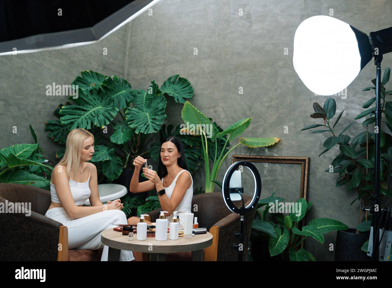Two beautiful content creator making natural beauty and cosmetic tutorial on green plant garden ...