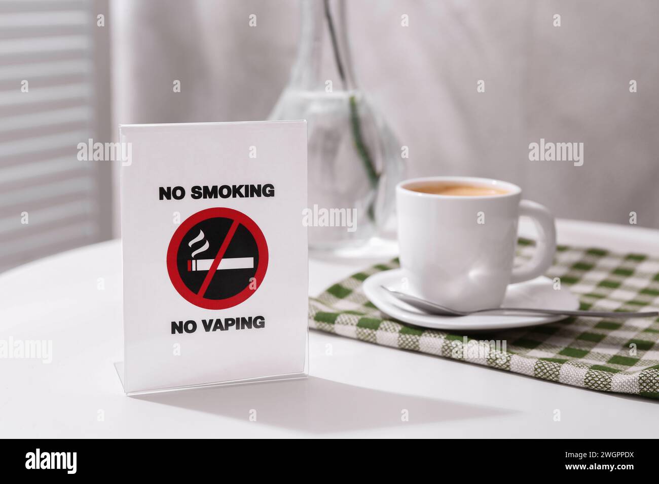 No Smoking No Vaping sign and cup of coffee on white table indoors ...