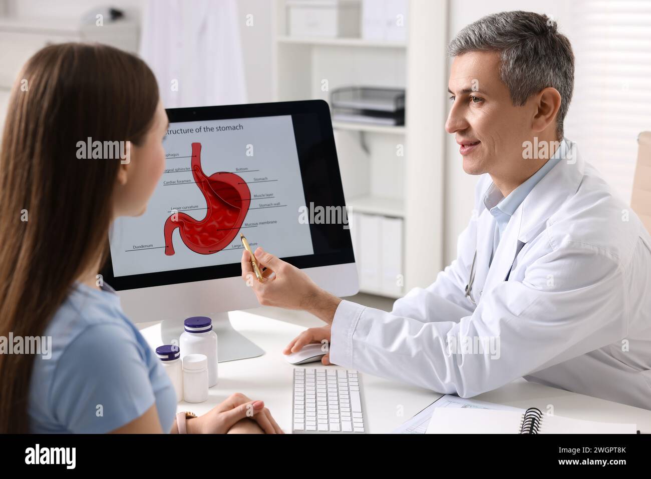 Gastroenterologist showing screen with illustration of human stomach ...